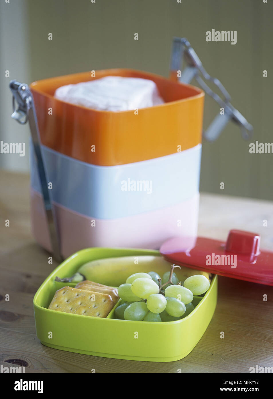 Multi coloured square lunch box with fruit and biscuits Stock Photo - Alamy