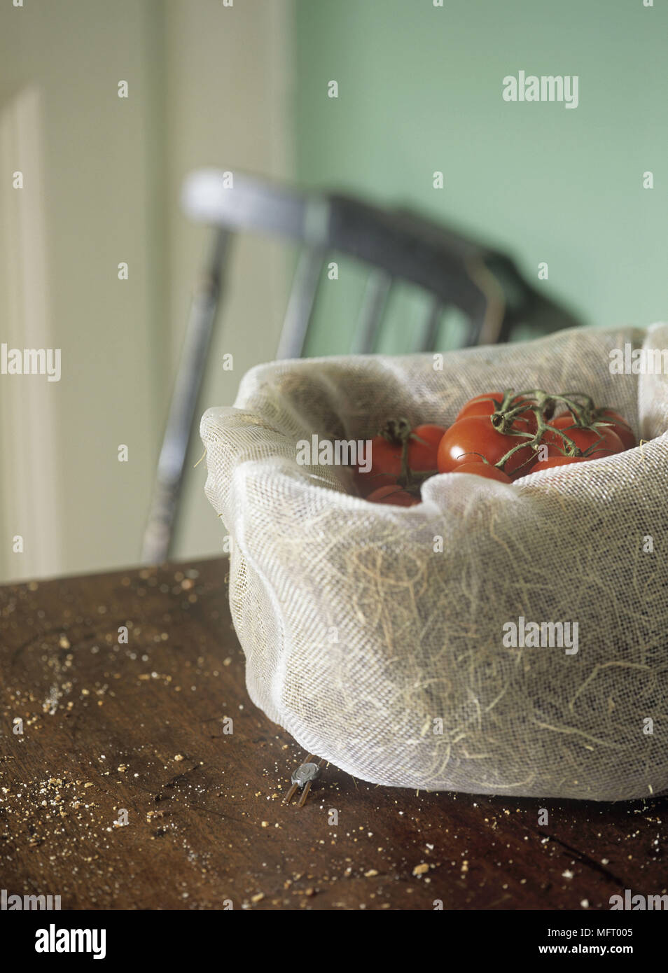 Bowl made of straw and plastic netting filled with small tomatoes on ...
