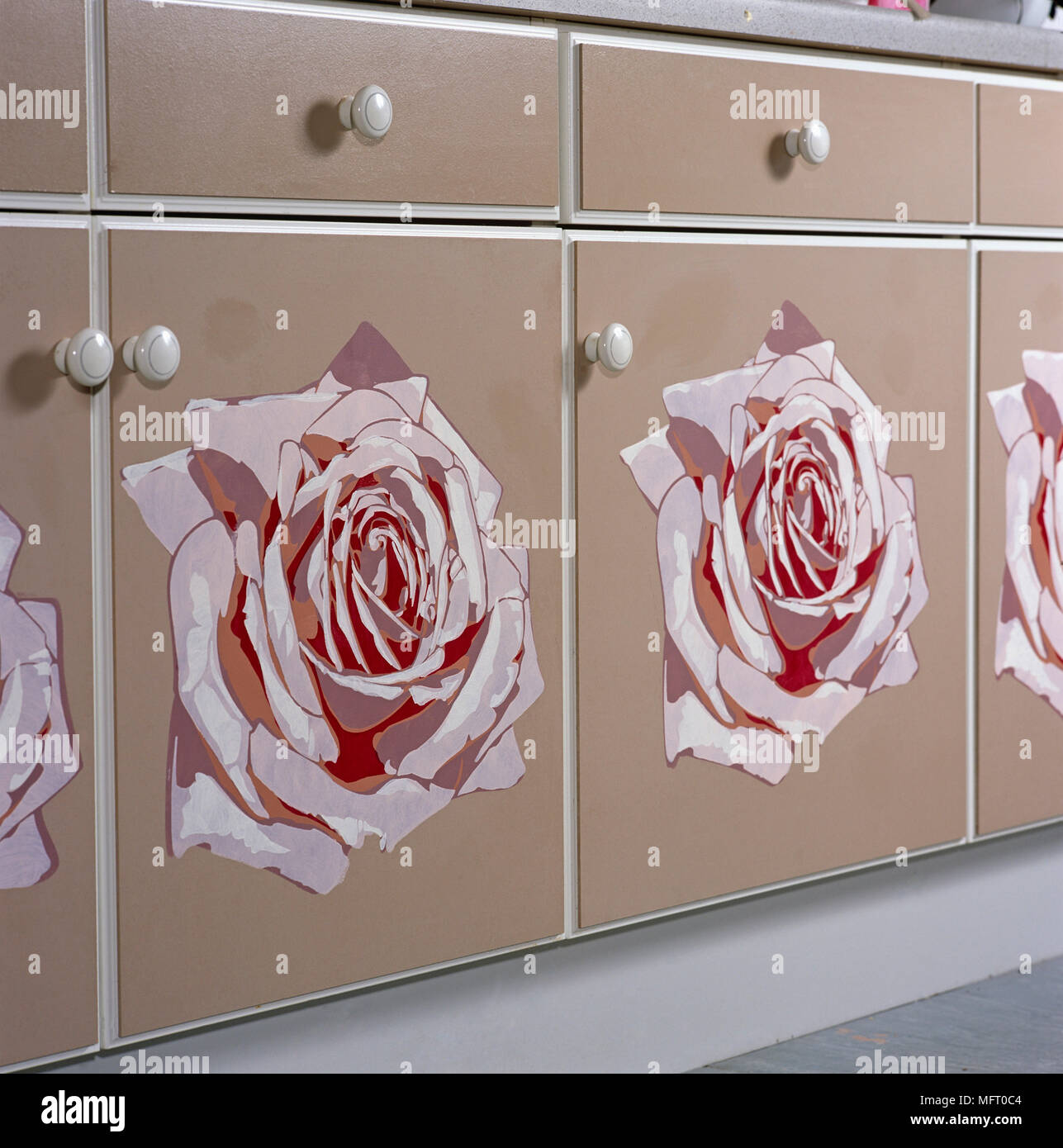 Fitted kitchen units with painted rose design Stock Photo - Alamy
