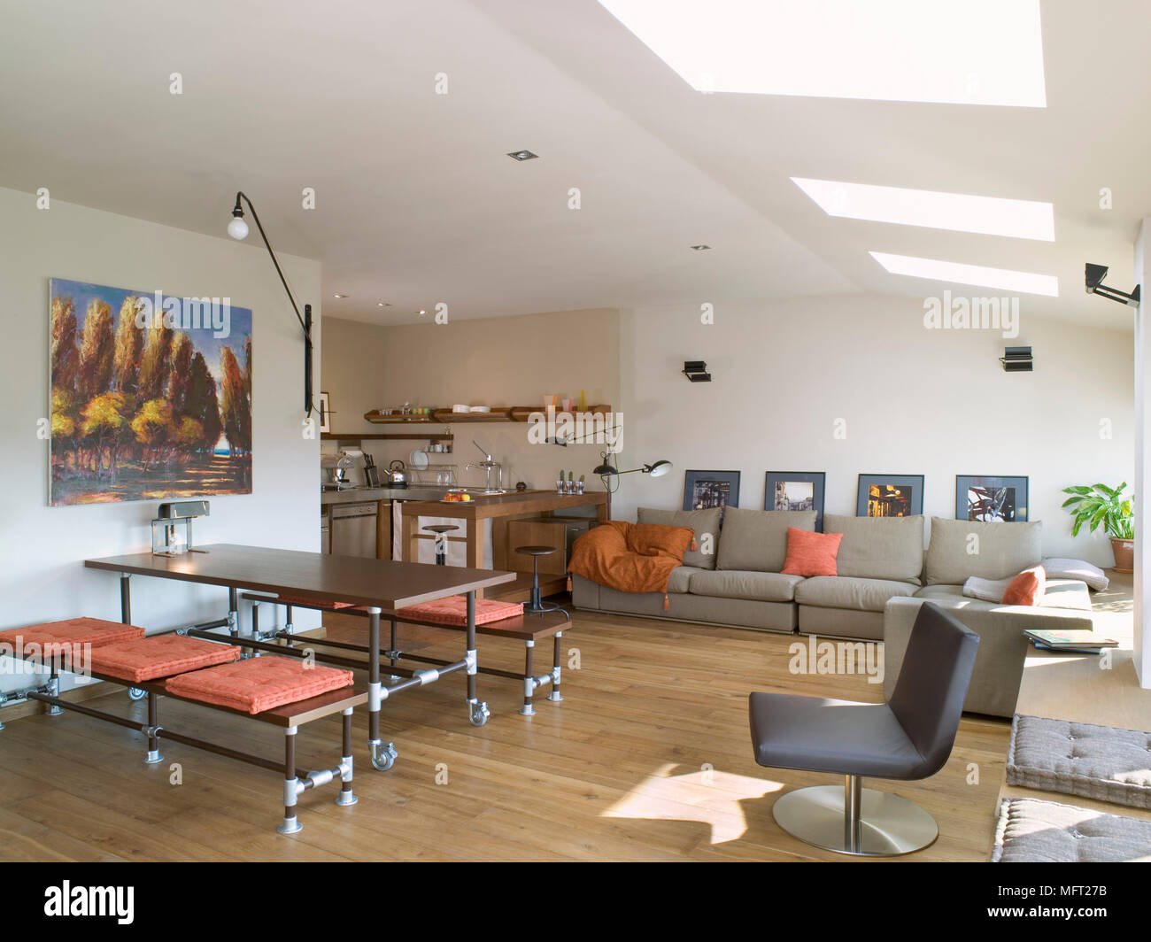 Open plan view of flat with wooden floor and furniture with painting ...