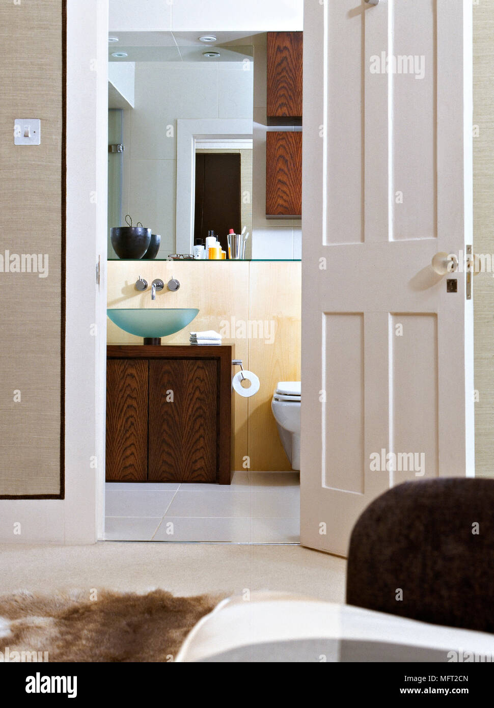 View through open door to en-suite bathroom with glass bowl washbasin ...