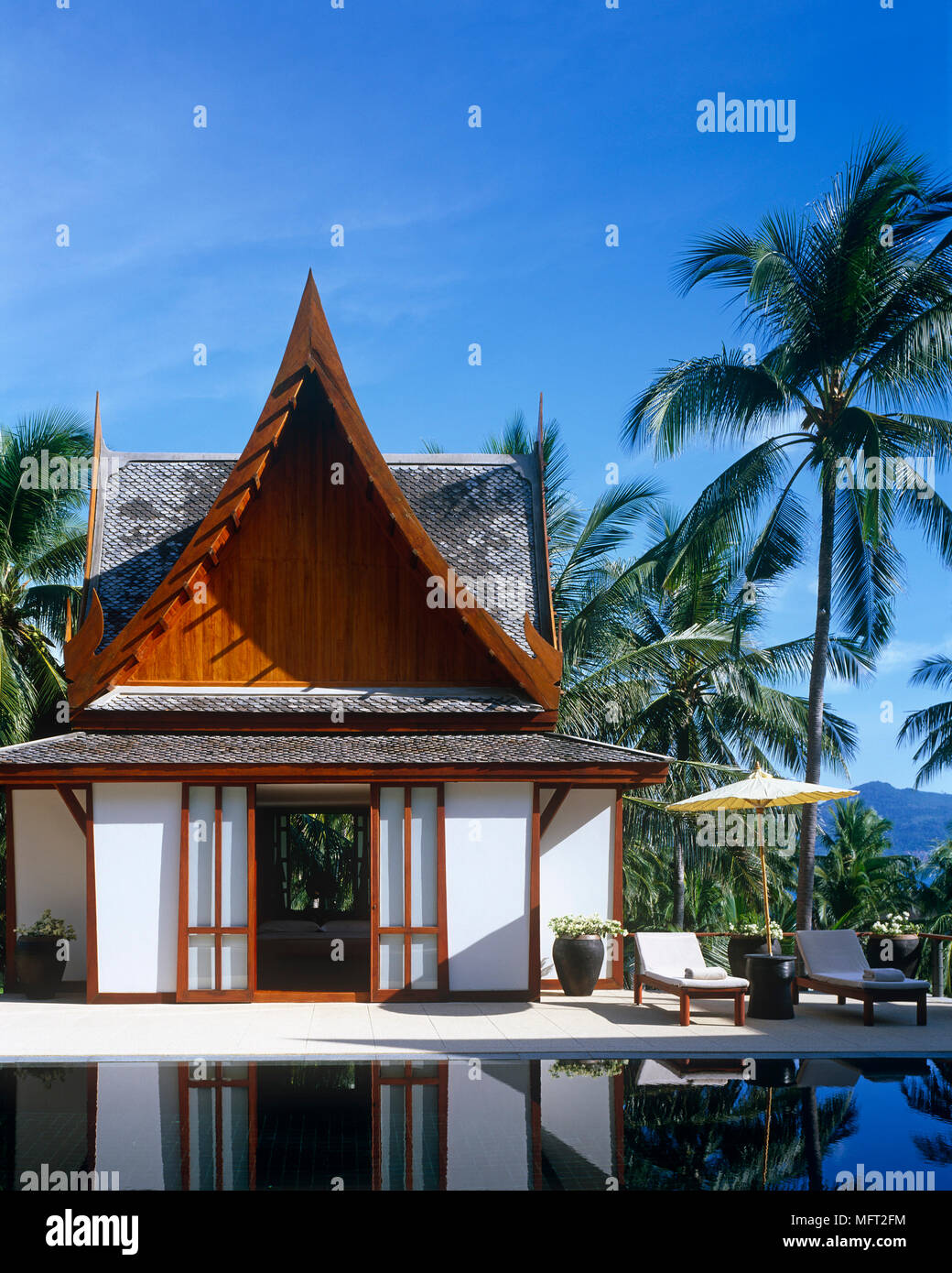 Private sala in grounds of Thai hotel resort with sun loungers beside ...