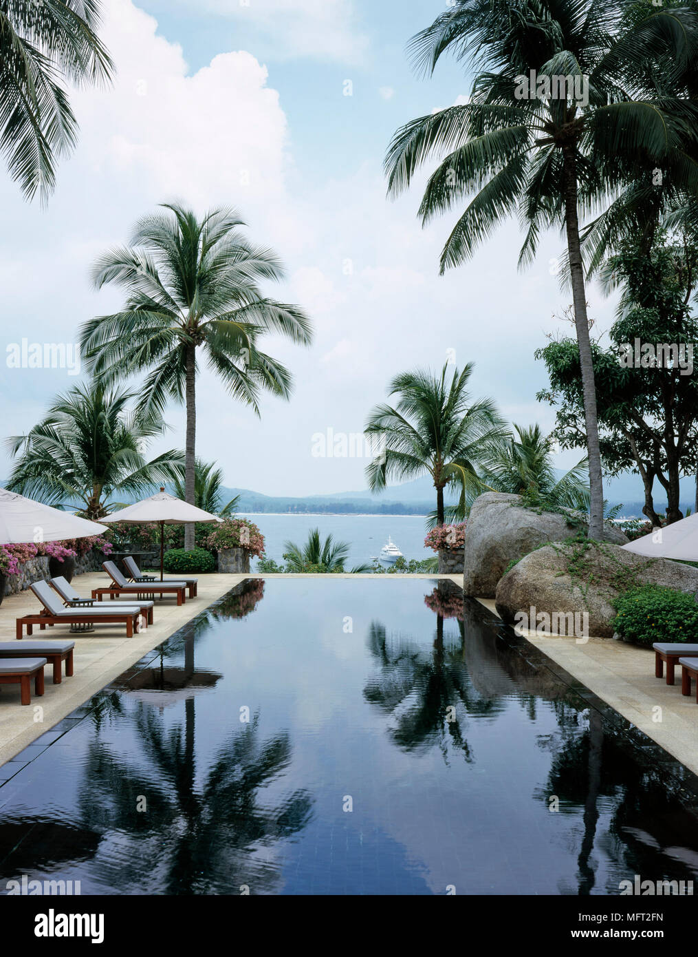 Hotel resort with sun loungers beside swimming pool Stock Photo - Alamy