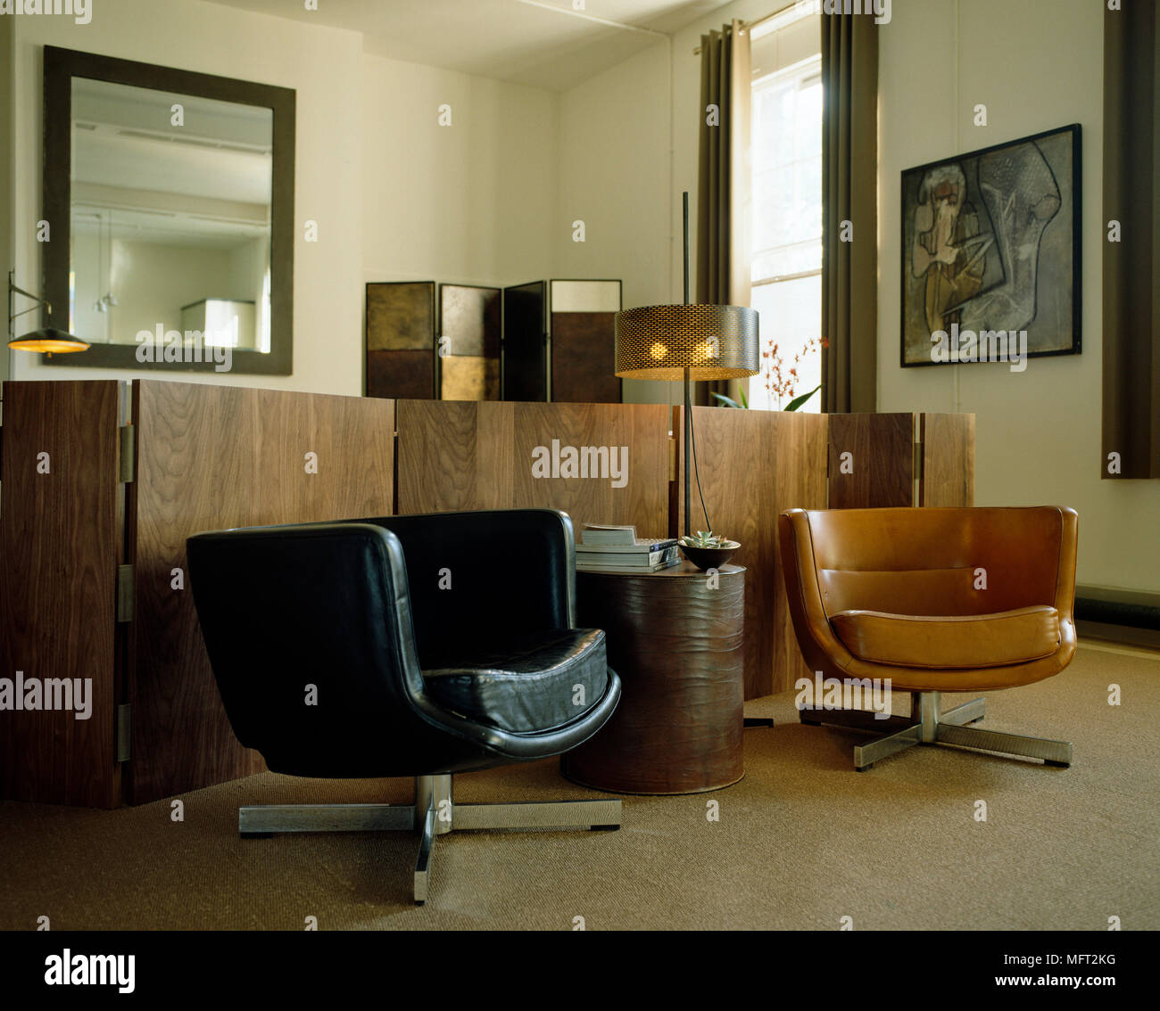 Retro style sitting room with leather armchairs and wooden screens ...