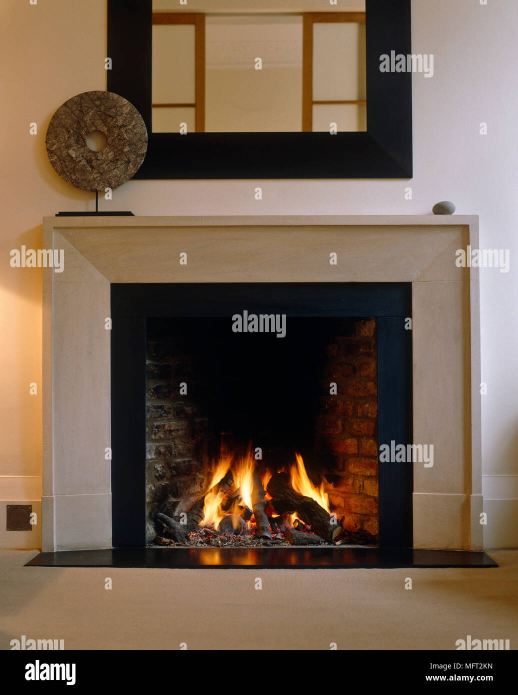 Sitting room detail with lit fire in monochrome fireplace Stock Photo ...