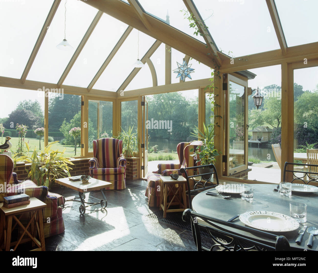 Upholstered armchairs in wooden conservatory Stock Photo - Alamy