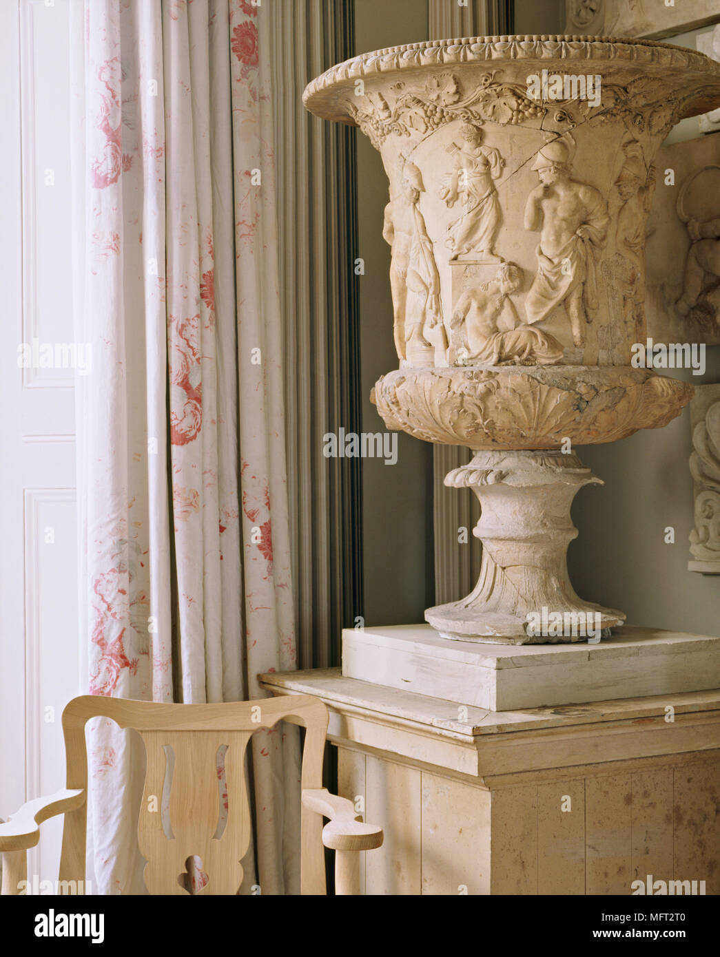 A detail of a stone carved urn, depicting roman figures set on wooden ...