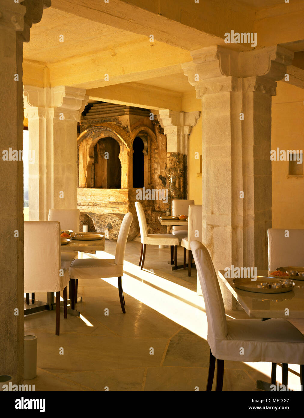 Hotel dining room stone pillars tables upholstered chairs interiors ...