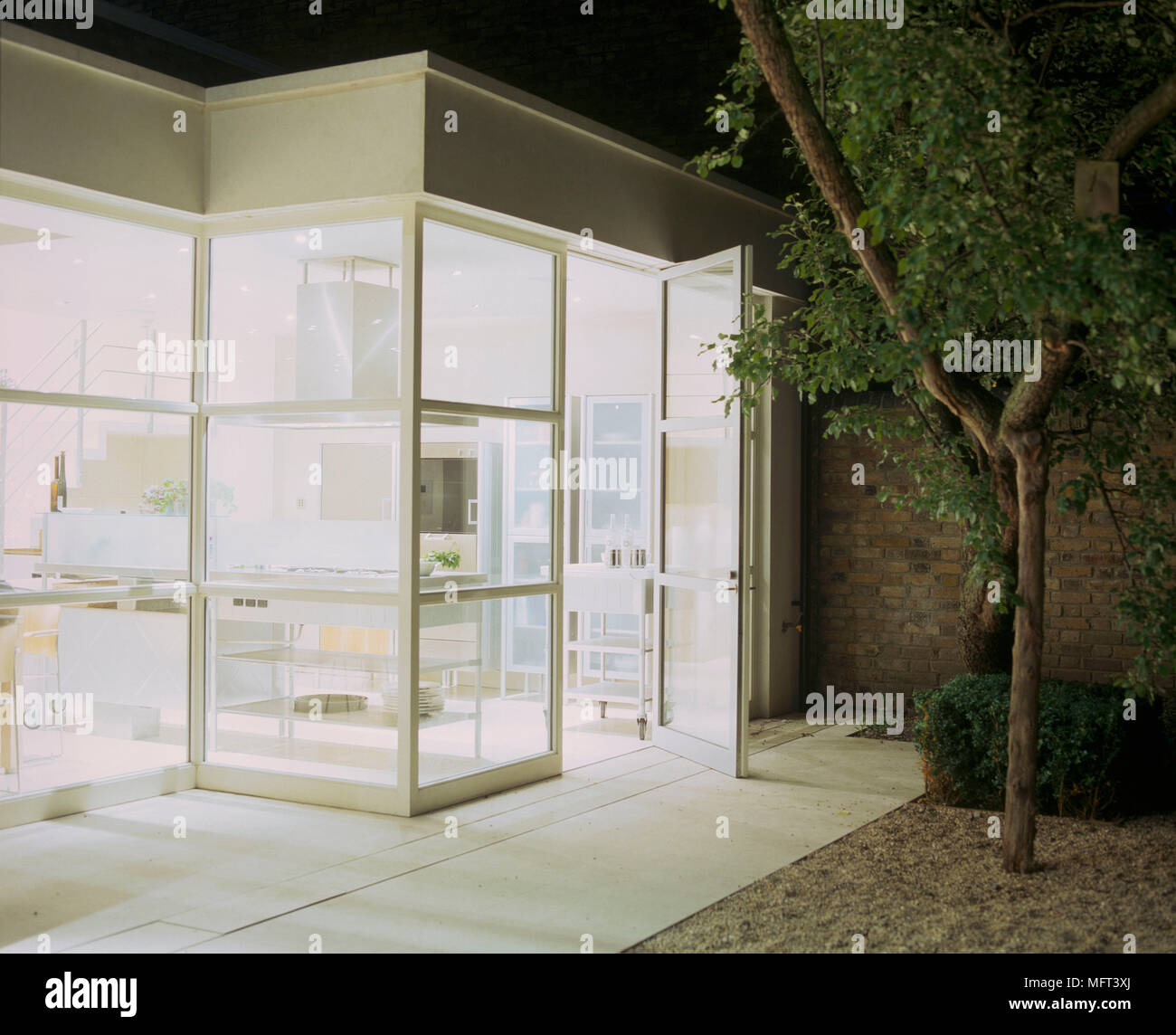 A night shot of a detail of the exterior of the rear of a modern house ...