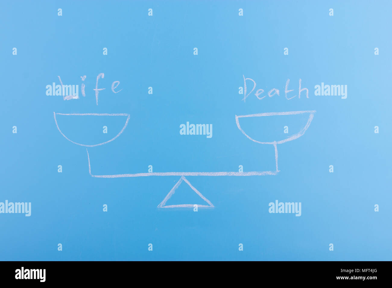 life and death on the scales on blue background Stock Photo - Alamy