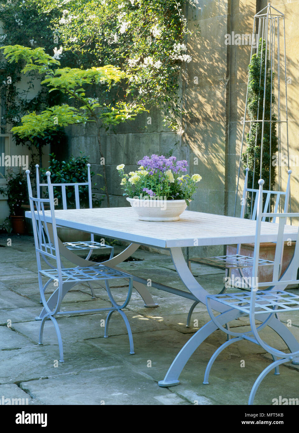 Table and chairs on paved stone patio Stock Photo - Alamy