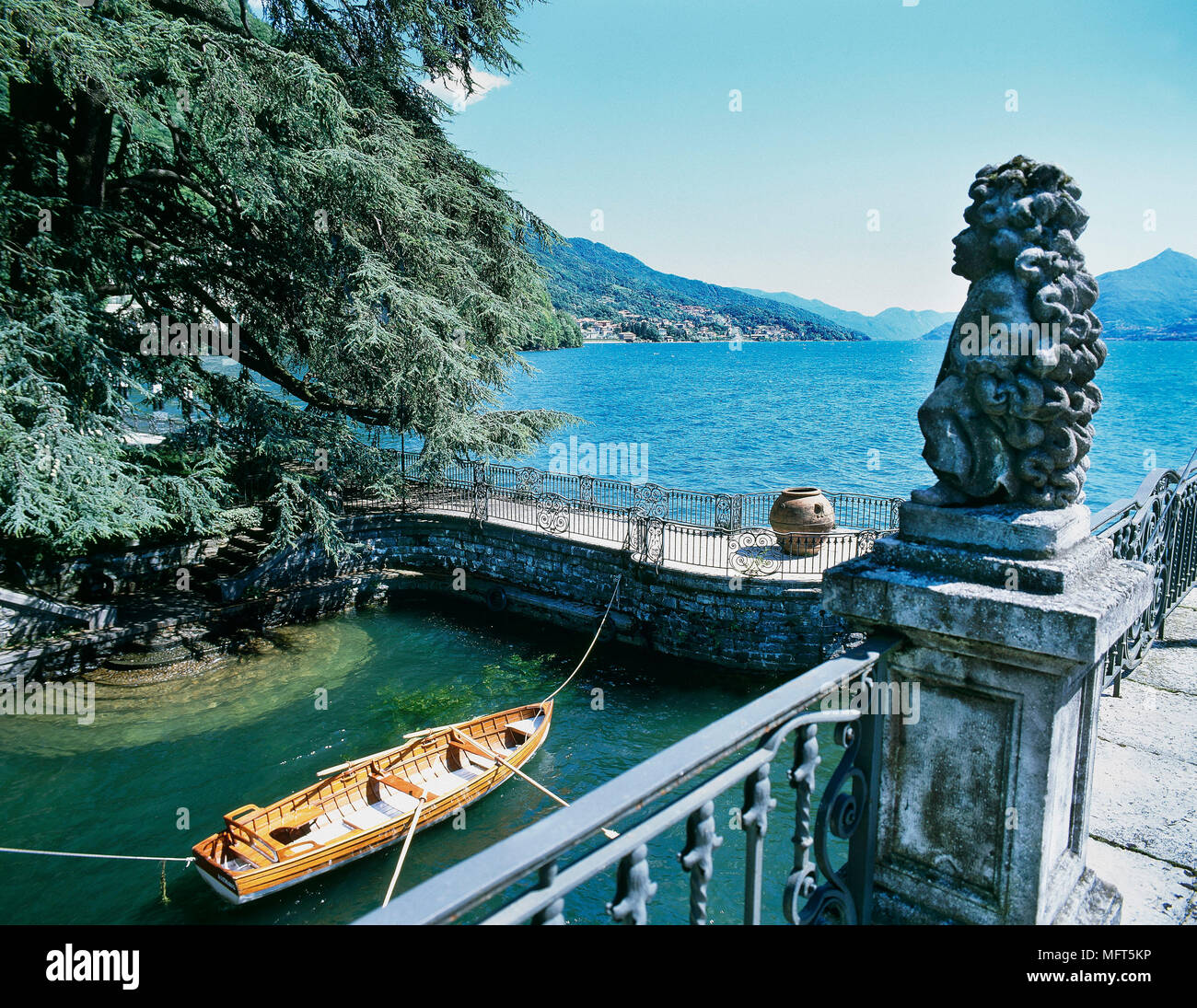 View from terrace of lake and jetty with boat attached to mooring Stock ...