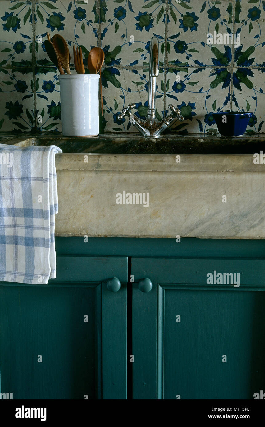 A detail of a rustic, country style kitchen with stone sink, pattern ...