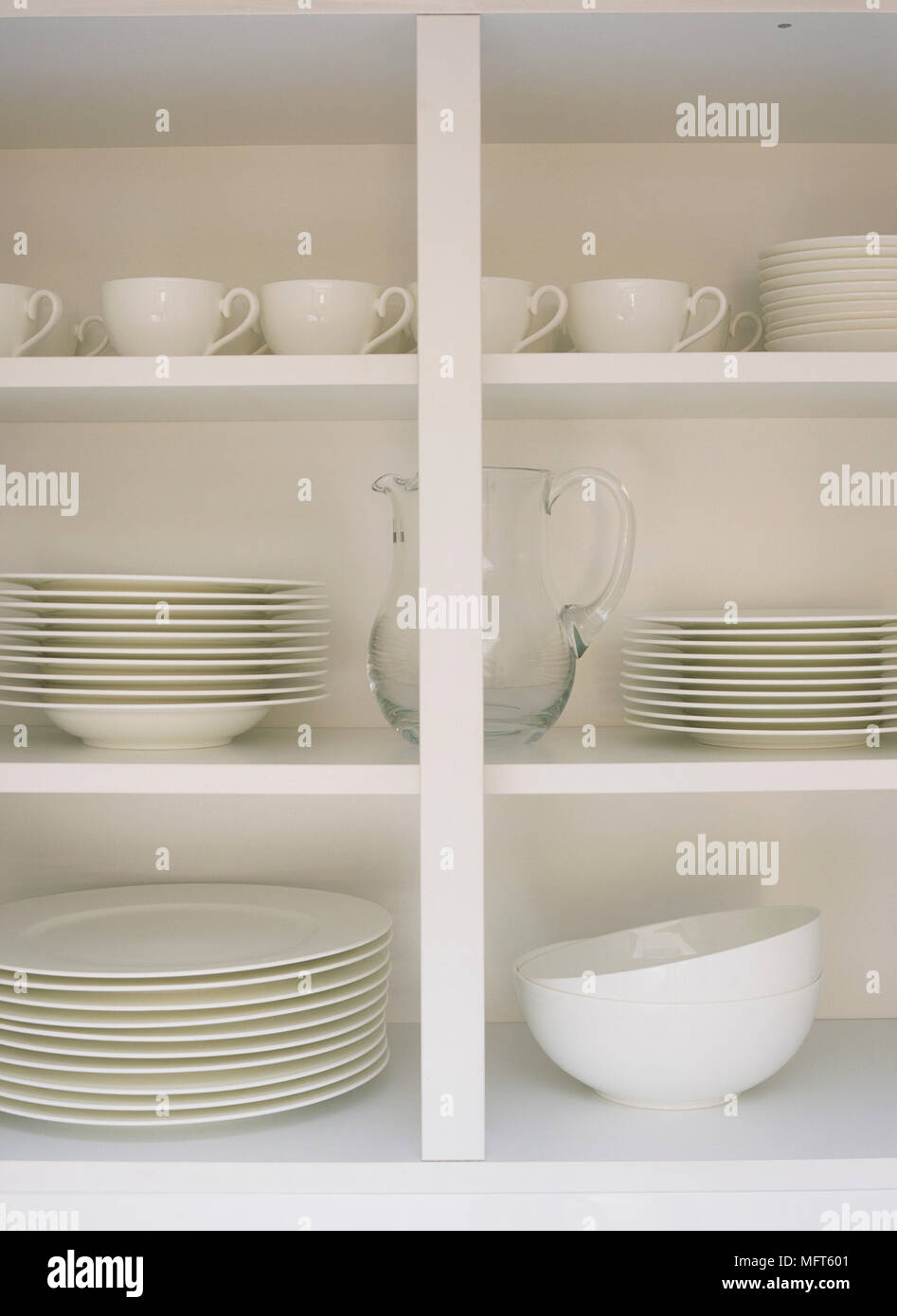 A detail of a modern kitchen showing shelves storing simple white ...