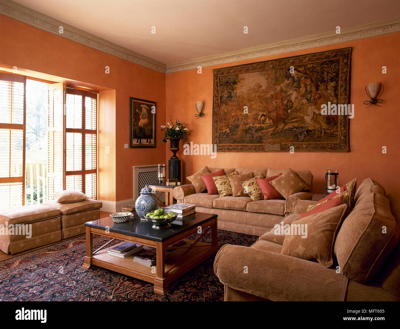 Orange sitting room with french window and sofas Stock Photo - Alamy