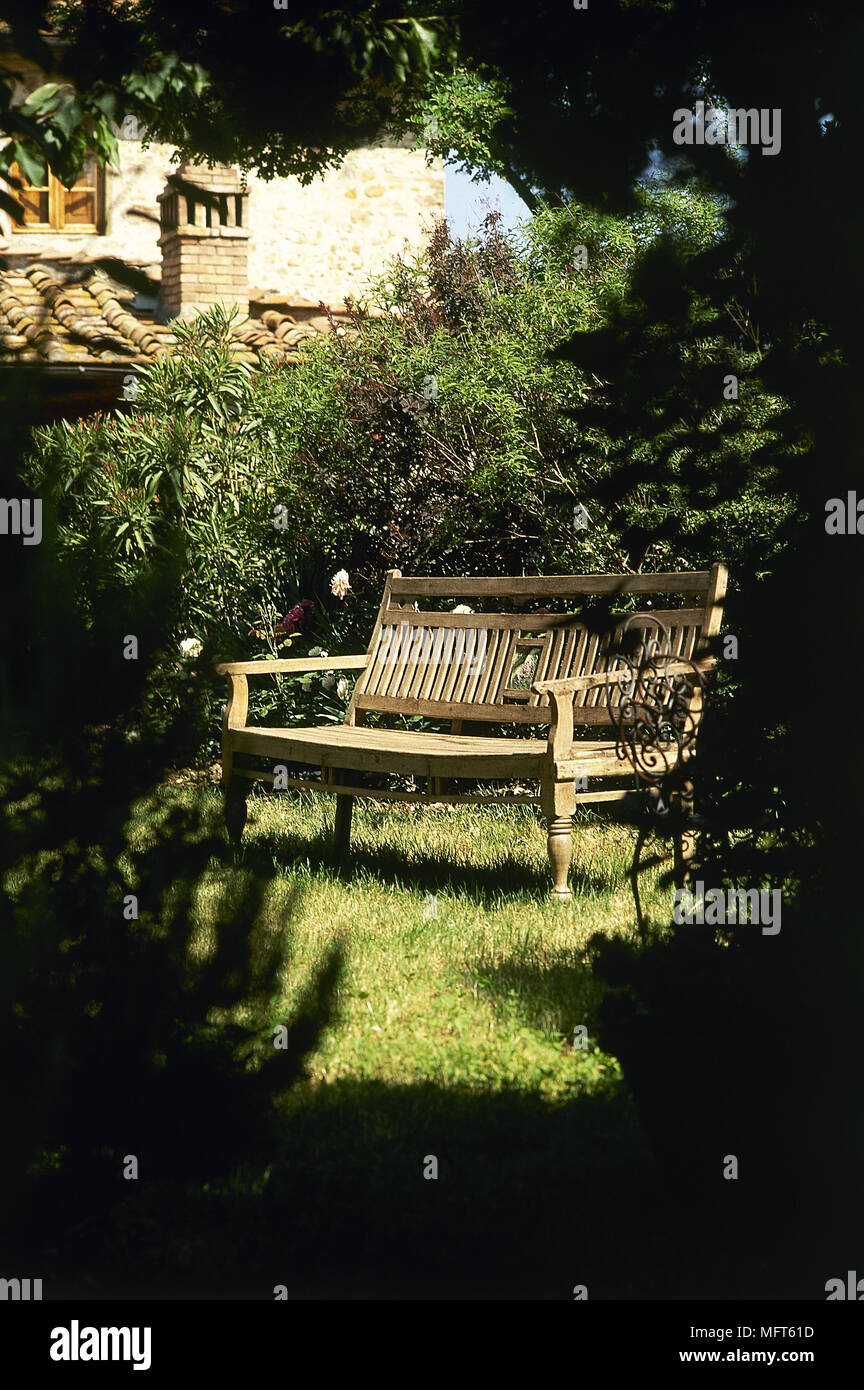 Wooden slatted bench seat in shady spot in garden Stock Photo - Alamy