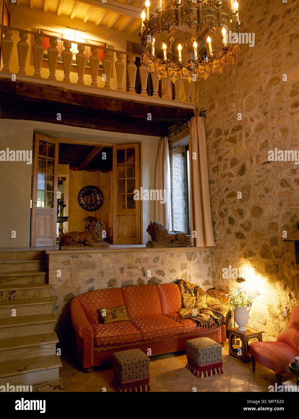 Rustic sitting room with exposed stone walls and step coming down into ...