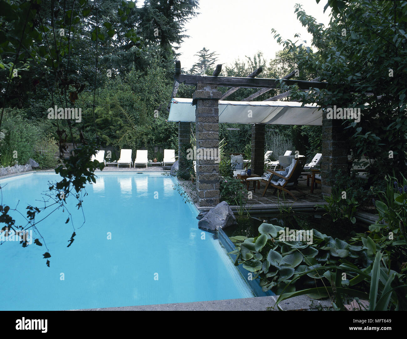 Outdoor swimming pool and covered patio area with sun loungers Stock ...