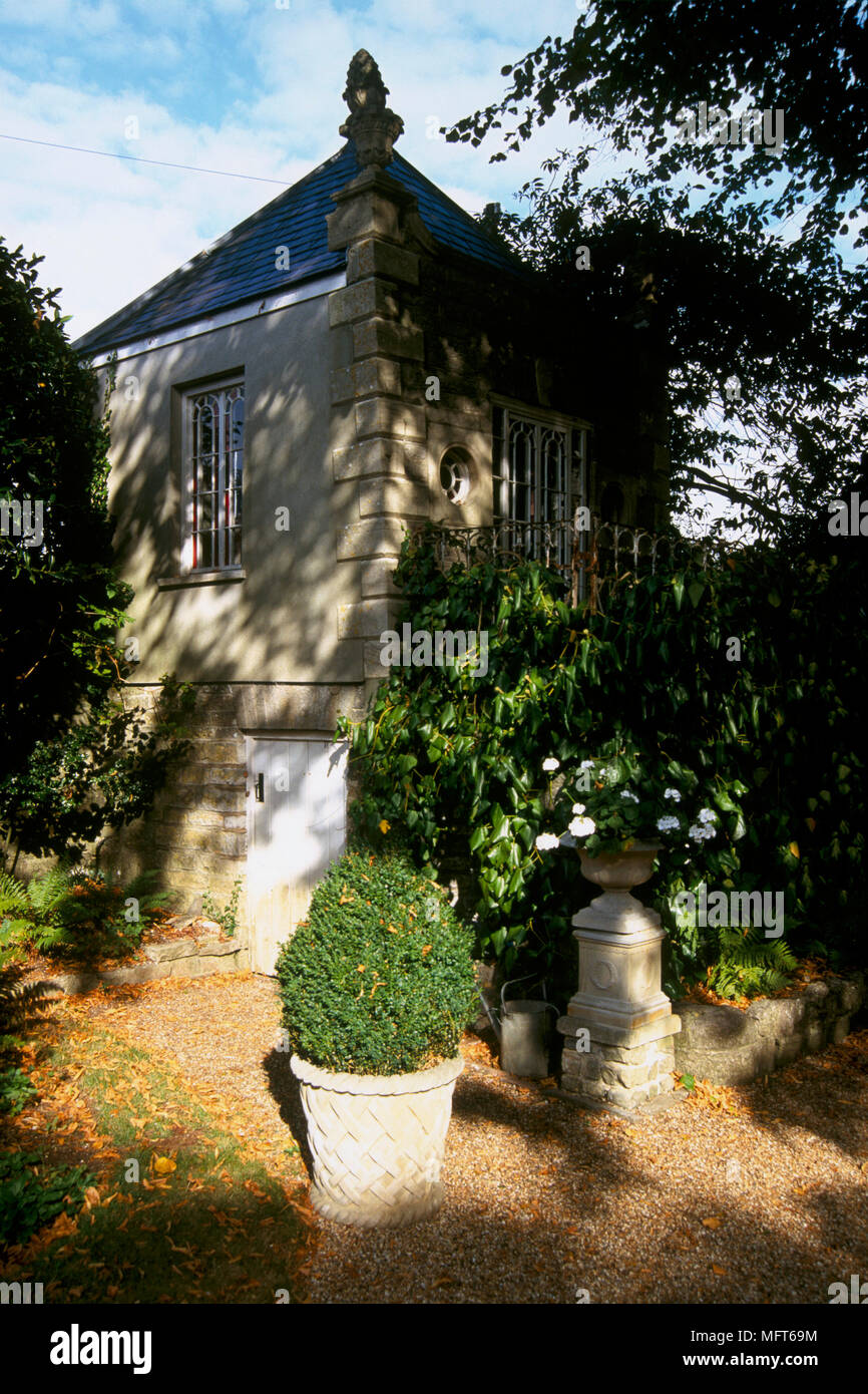 A garden detail showing a stone summer house, trees and shady area ...
