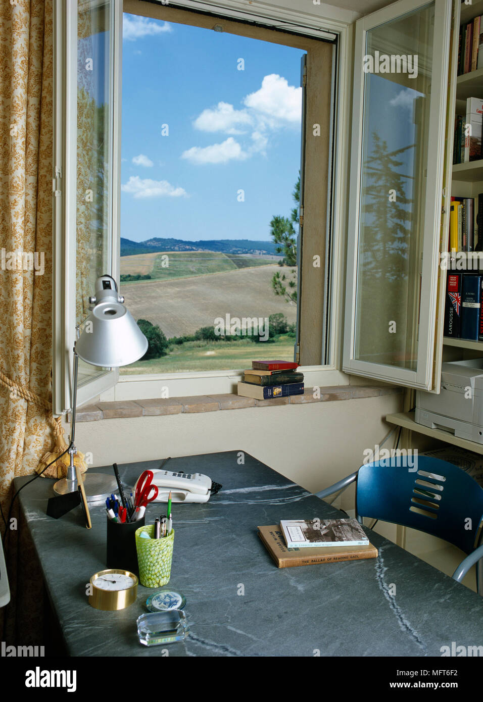 Marble top table beneath open window with view overlooking the Tuscan ...
