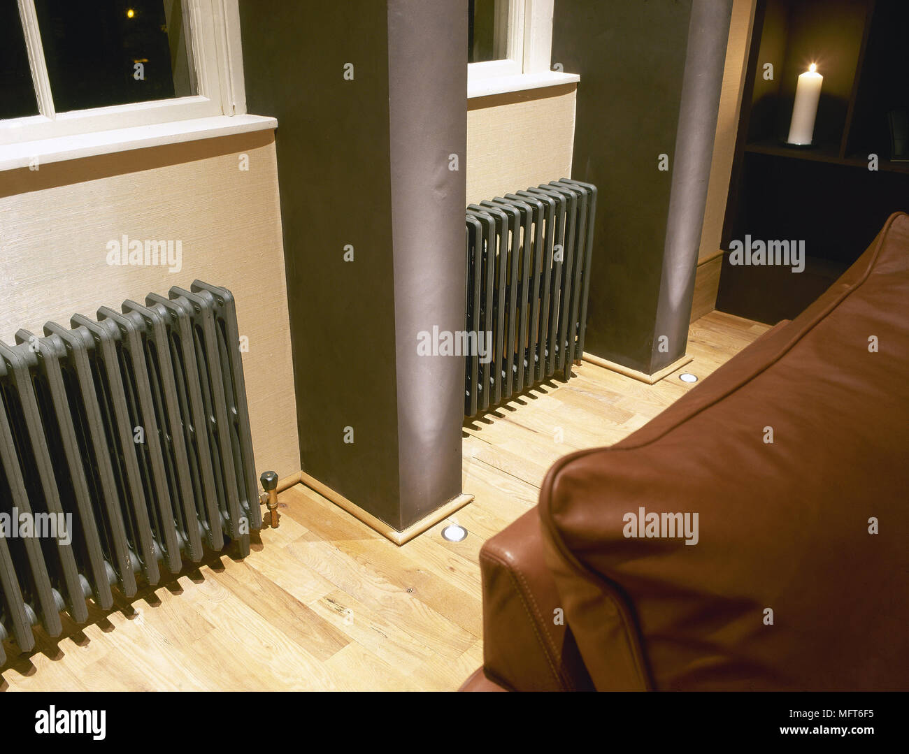 Detail of a sitting room with a wood floor and two radiators under the ...