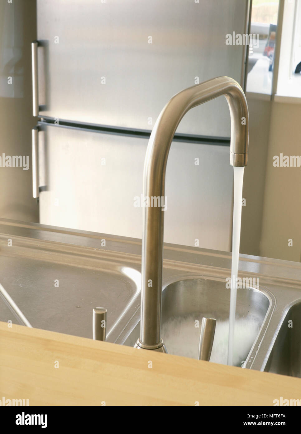 A detail of a modern kitchen showing a stainless steel mixer tap with ...