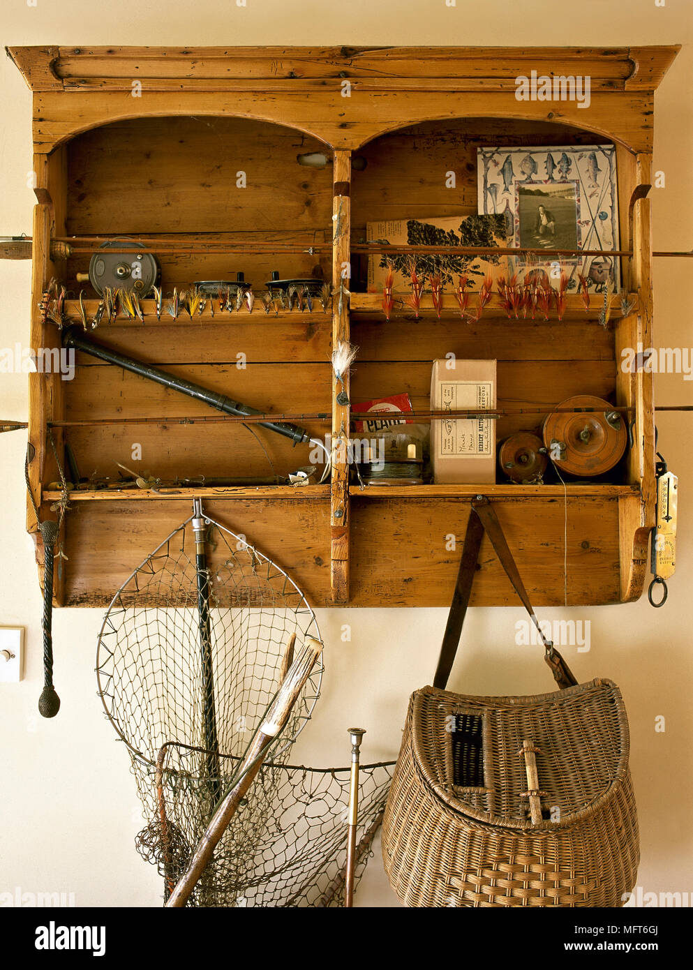 Wooden open display shelf with fishing tackle and a hanging fisherman's ...