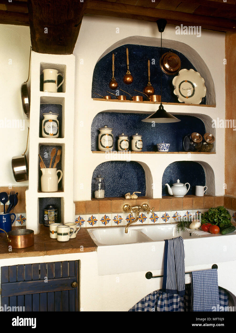 Rustic, country kitchen detail with curving niche shelving over a ...