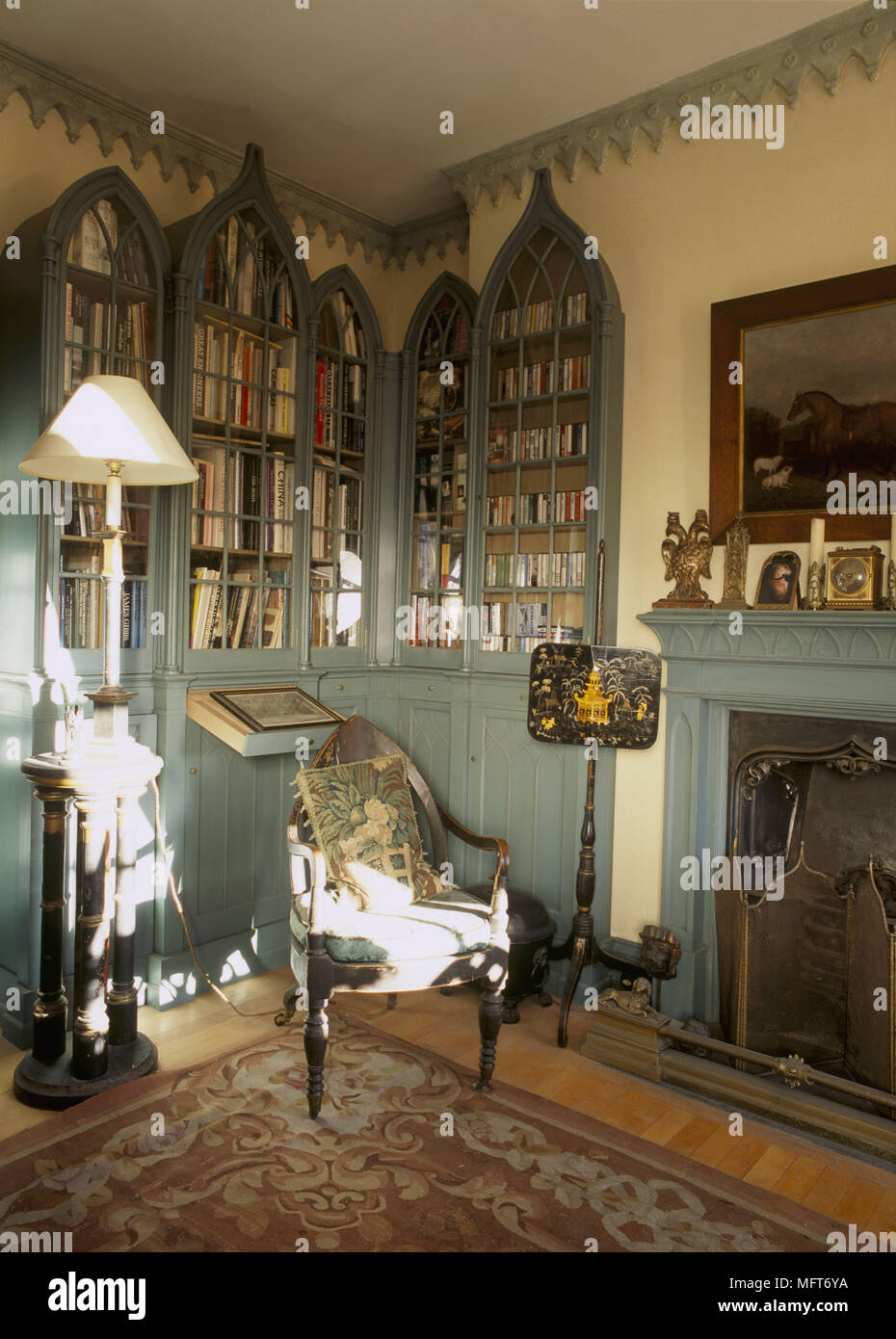 A traditional yellow library room fireplace built in painted book cases ...