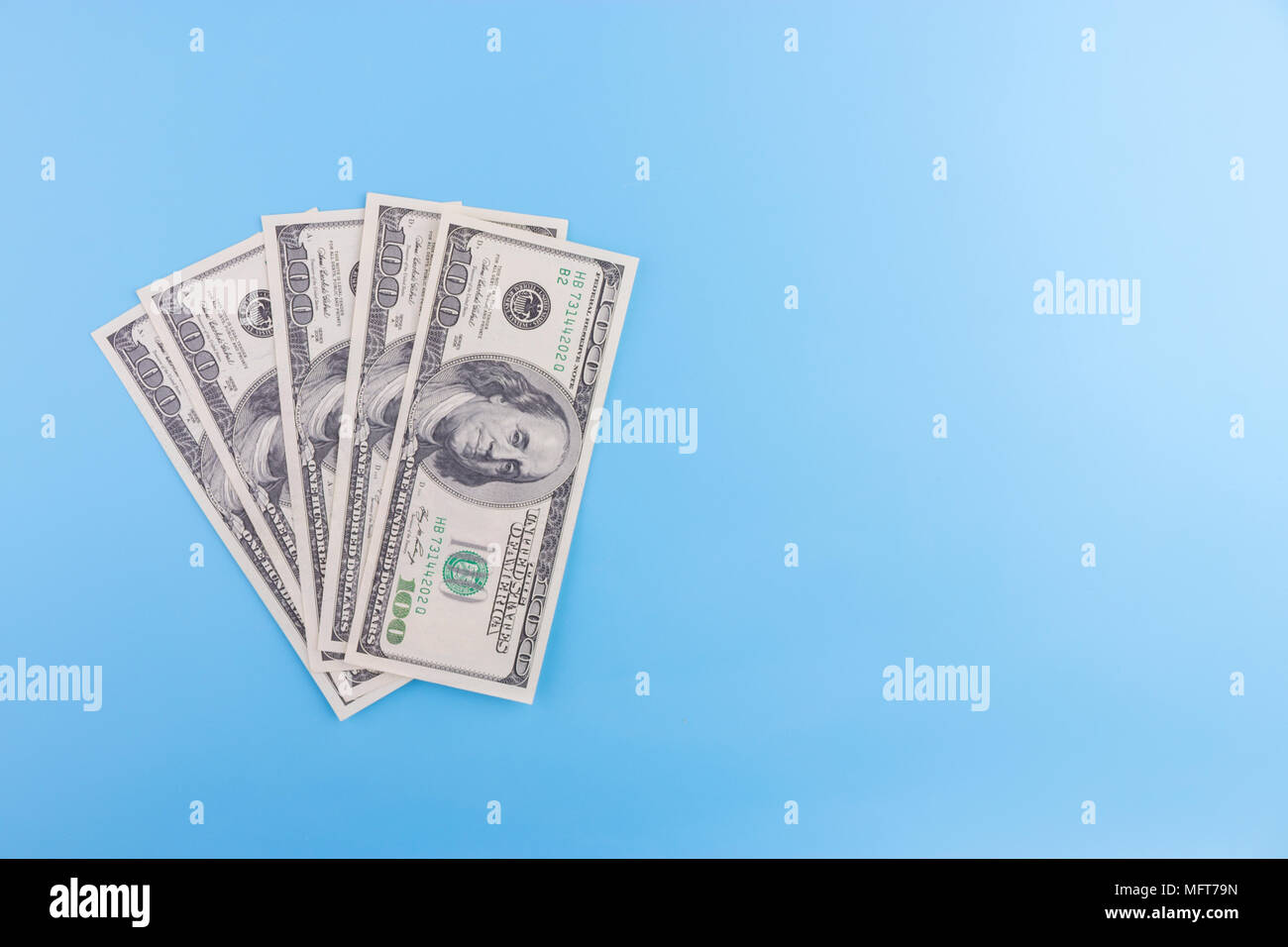 hundred dollar bills on the blue background Stock Photo - Alamy