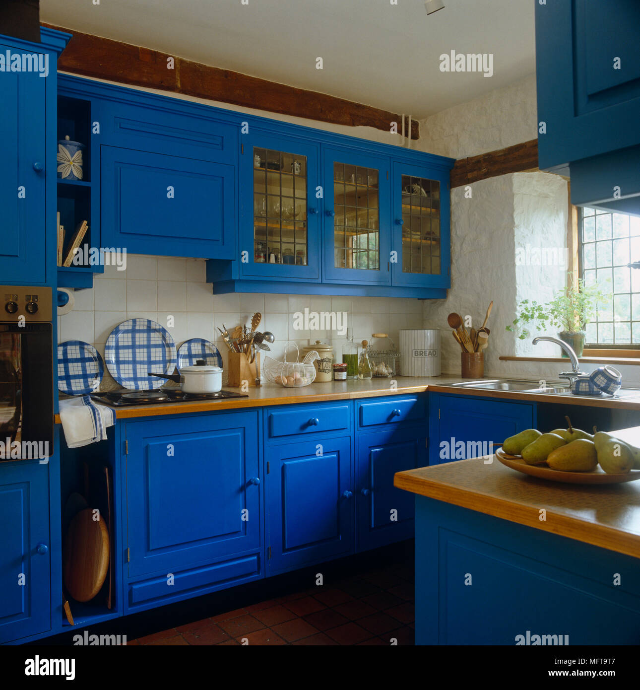 Country style kitchen with blue fitted units with tiled wall Stock ...
