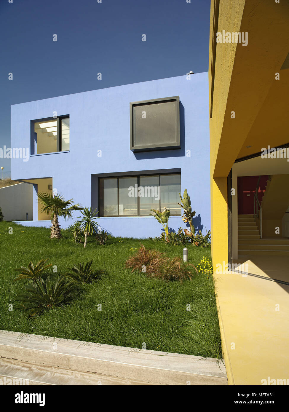 Exterior of new build blue and yellow house and garden Stock Photo - Alamy