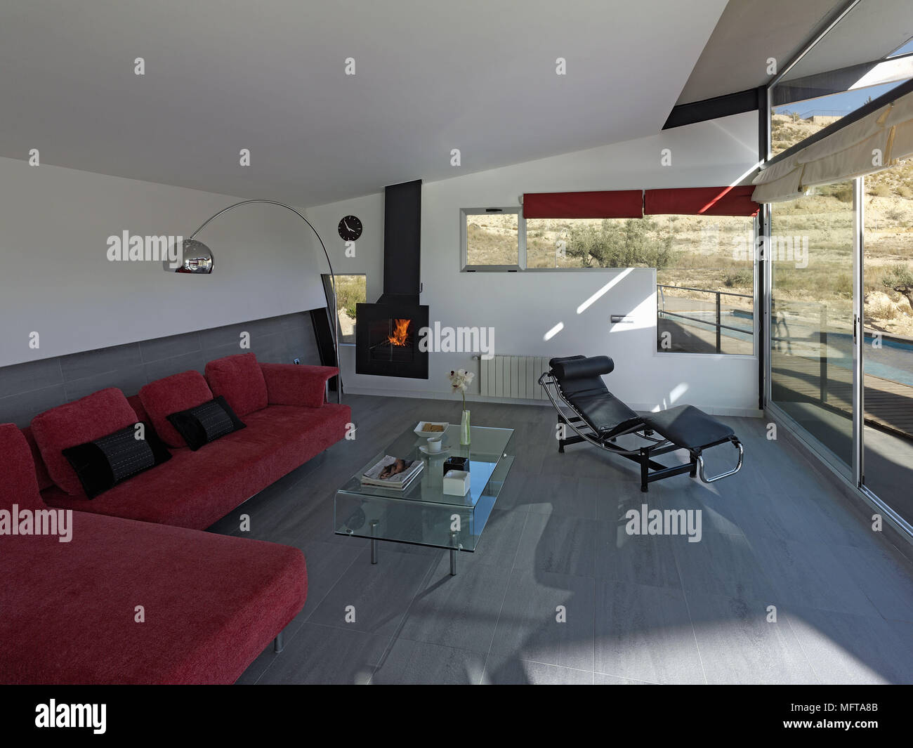 Red seating and le Corbusier recliner in modern sitting room Stock ...