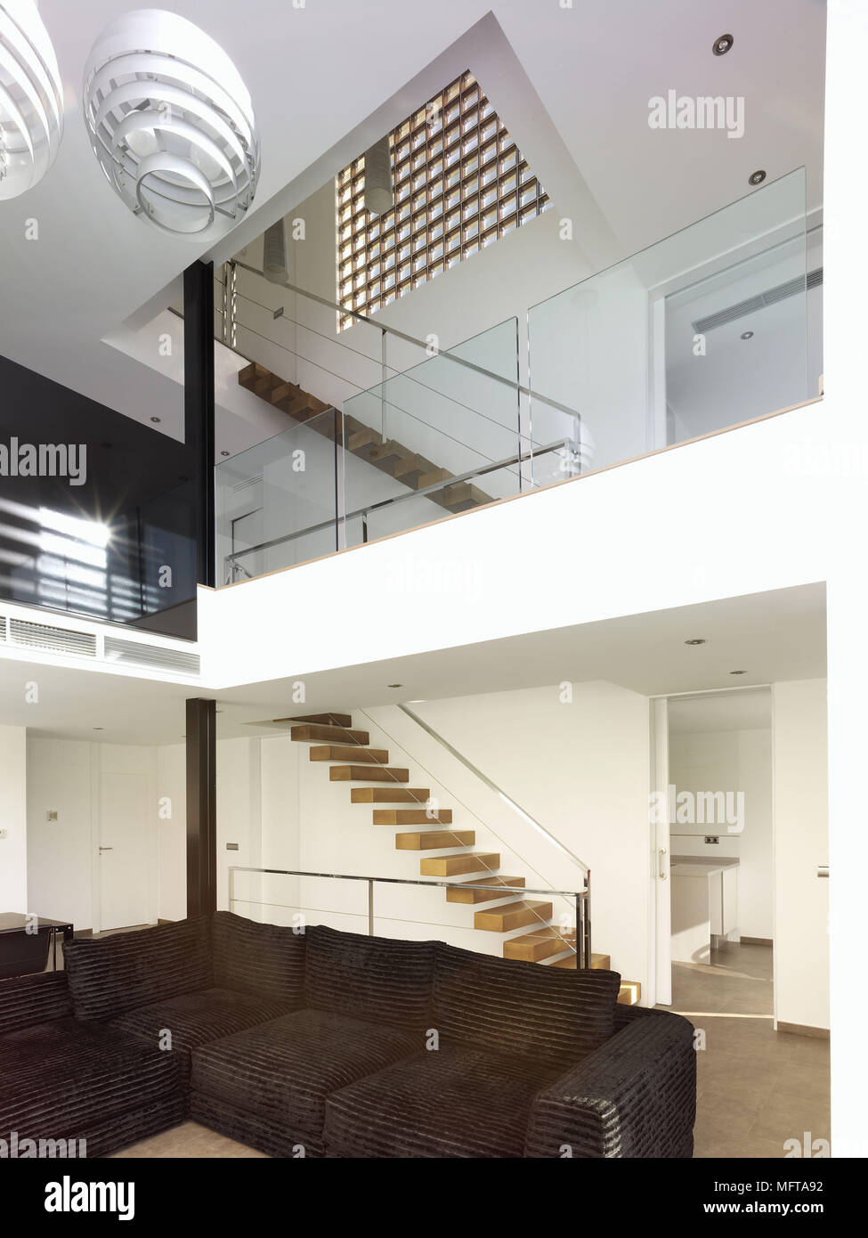 Seating in spacious modern open plan room with upper gallery floor ...