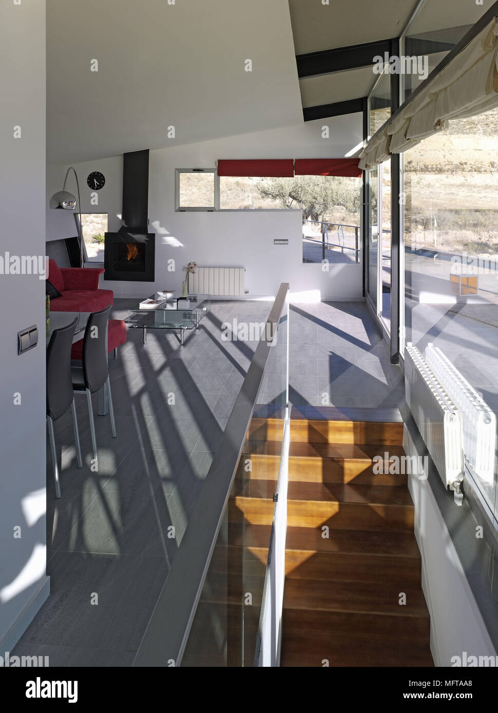 Stairs leading down from modern sitting room with floor to ceiling ...