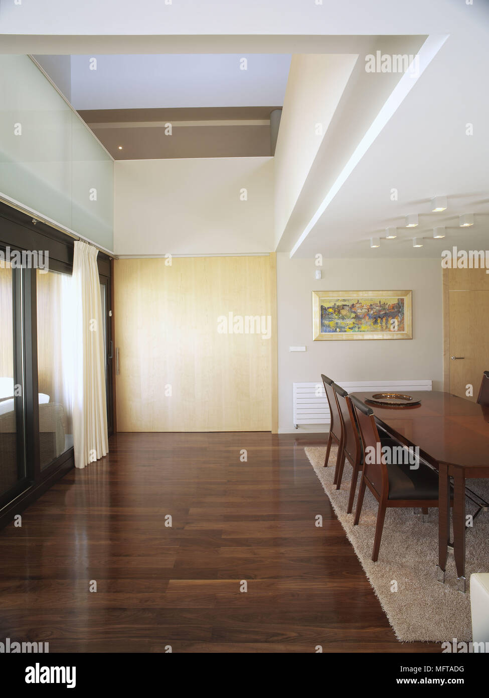Wooden table and chairs in spacious dining room with wooden floor Stock ...
