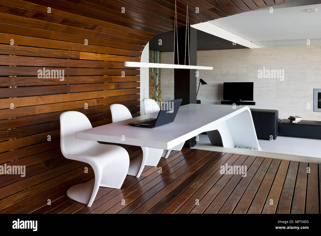 Verner Panton dining chairs at white table in modern wood panelled room ...