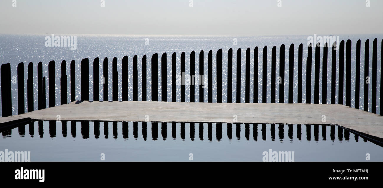 Fencing surrounding infinity pool overlooking ocean Stock Photo - Alamy