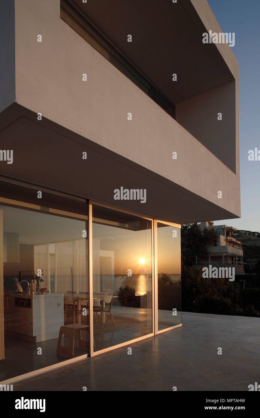 Exterior of modern house with setting sun reflected in window Stock ...