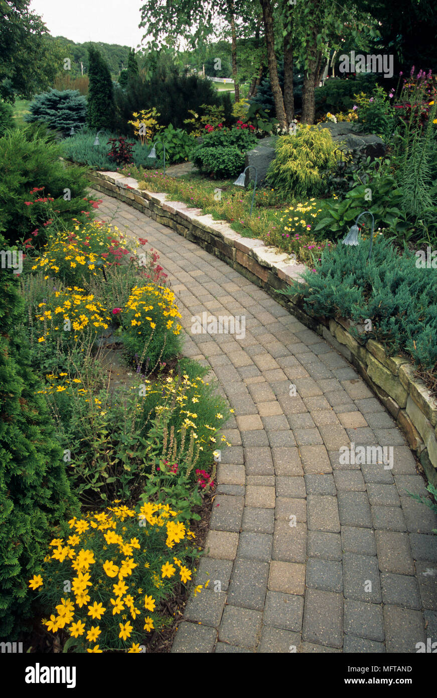 Curved brick path with flower beds Stock Photo - Alamy
