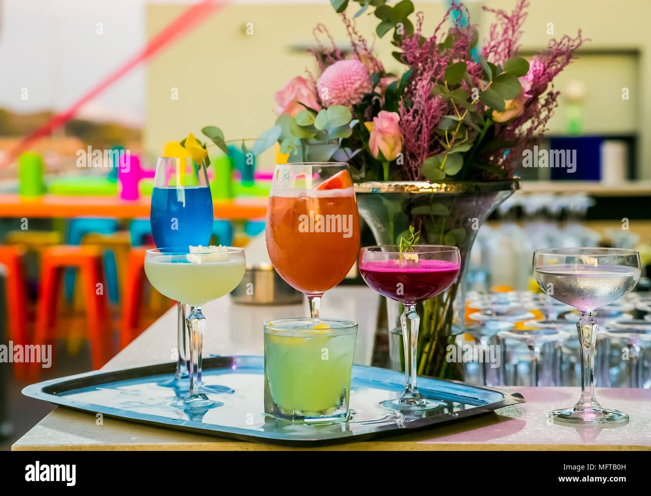 A waiter tray of Multi color Cocktail drinks on a bar counter for gala ...