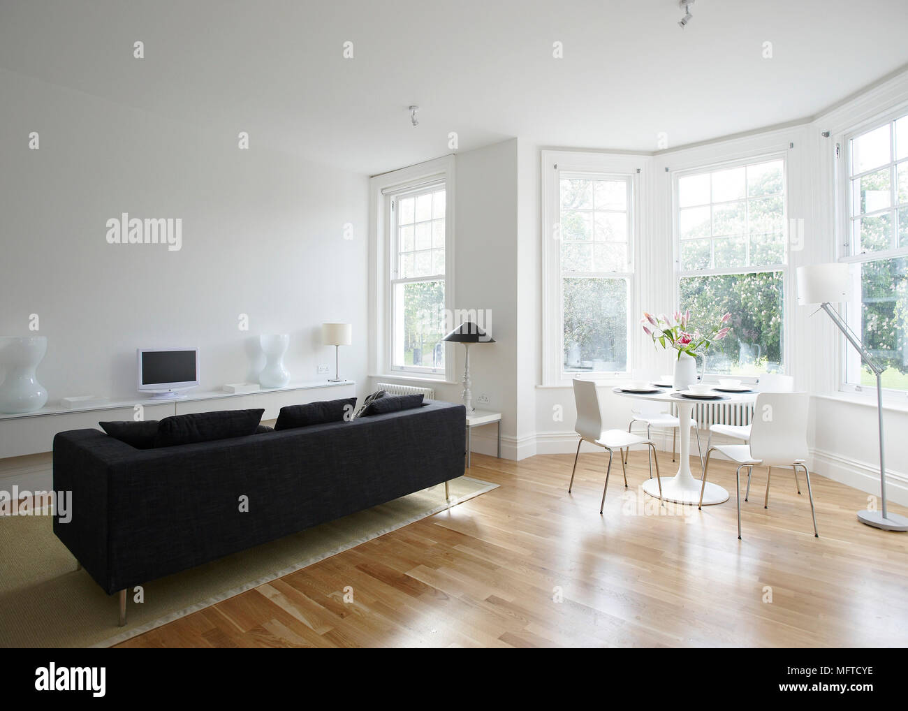 Dining table and chairs in modern open plan room with sitting area ...