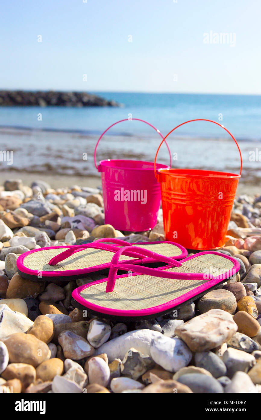 Flip-flops and plastic buckets on beach Stock Photo - Alamy