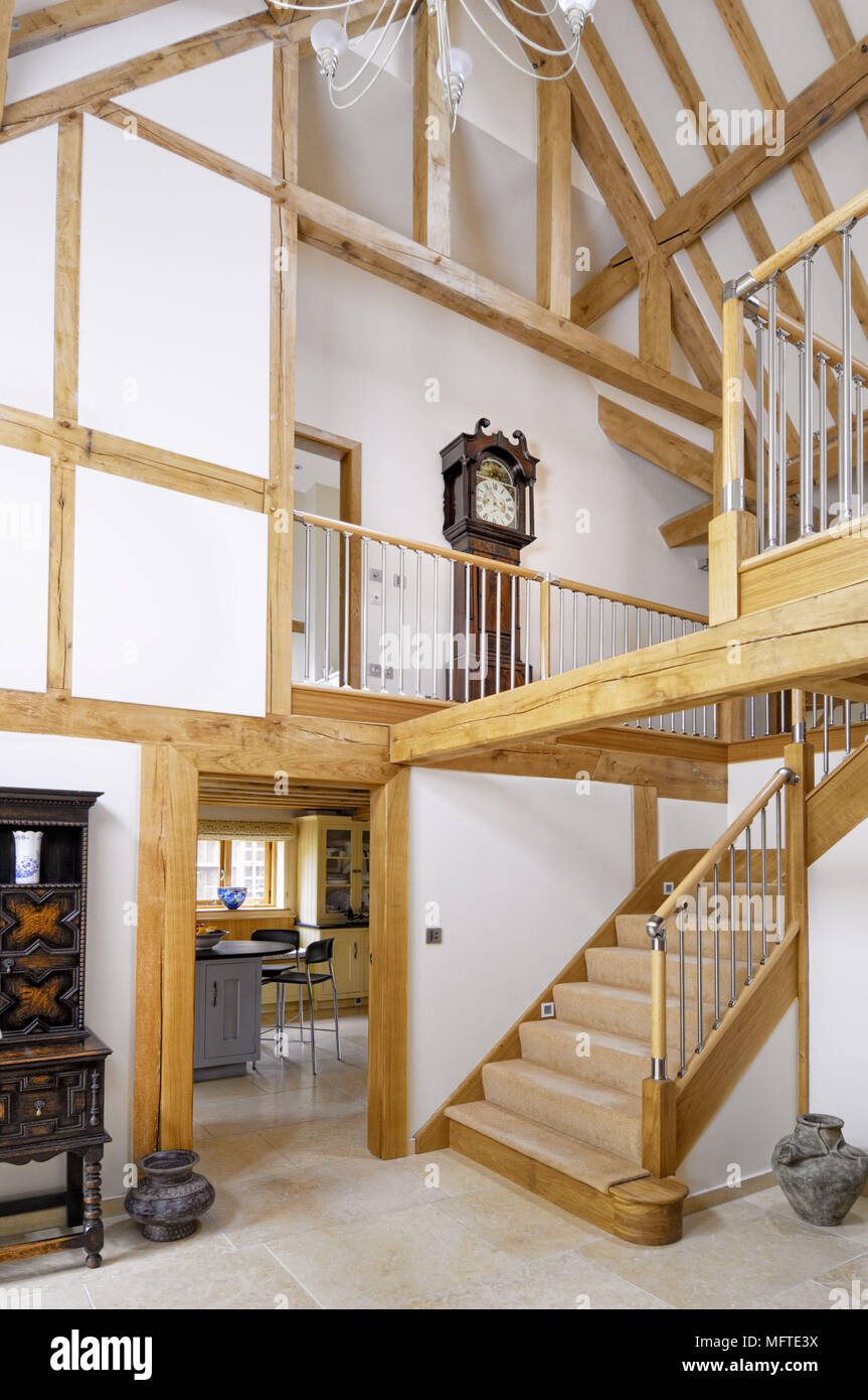 Wooden staircase in double height hallway Stock Photo - Alamy