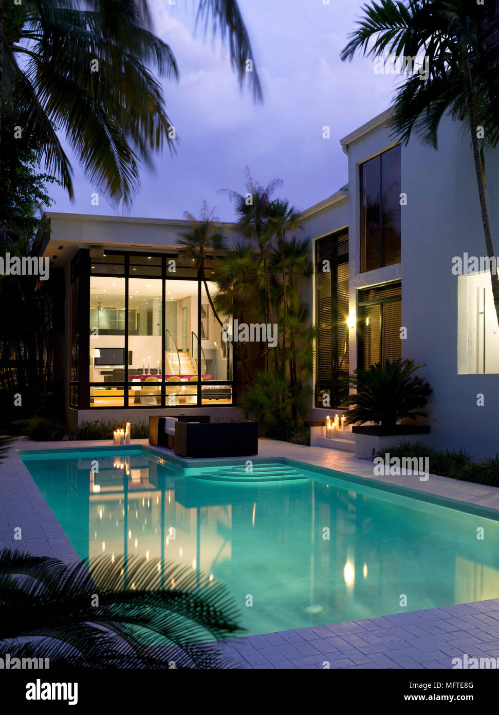 Exterior of modern house with swimming pool lit at night Stock Photo ...