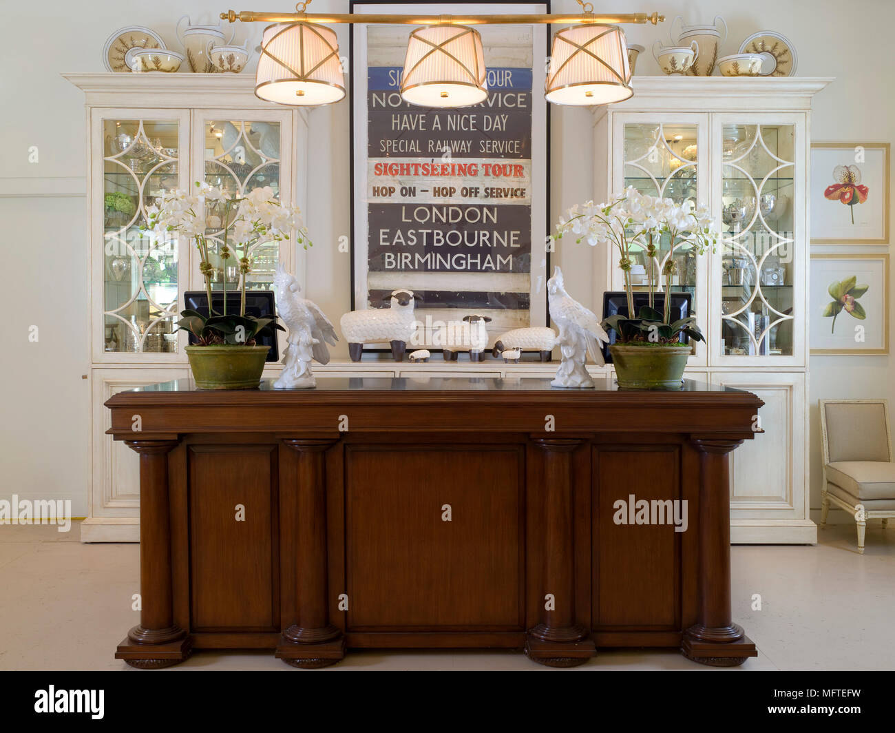 Ceiling lights above dark wood table with display units in background ...