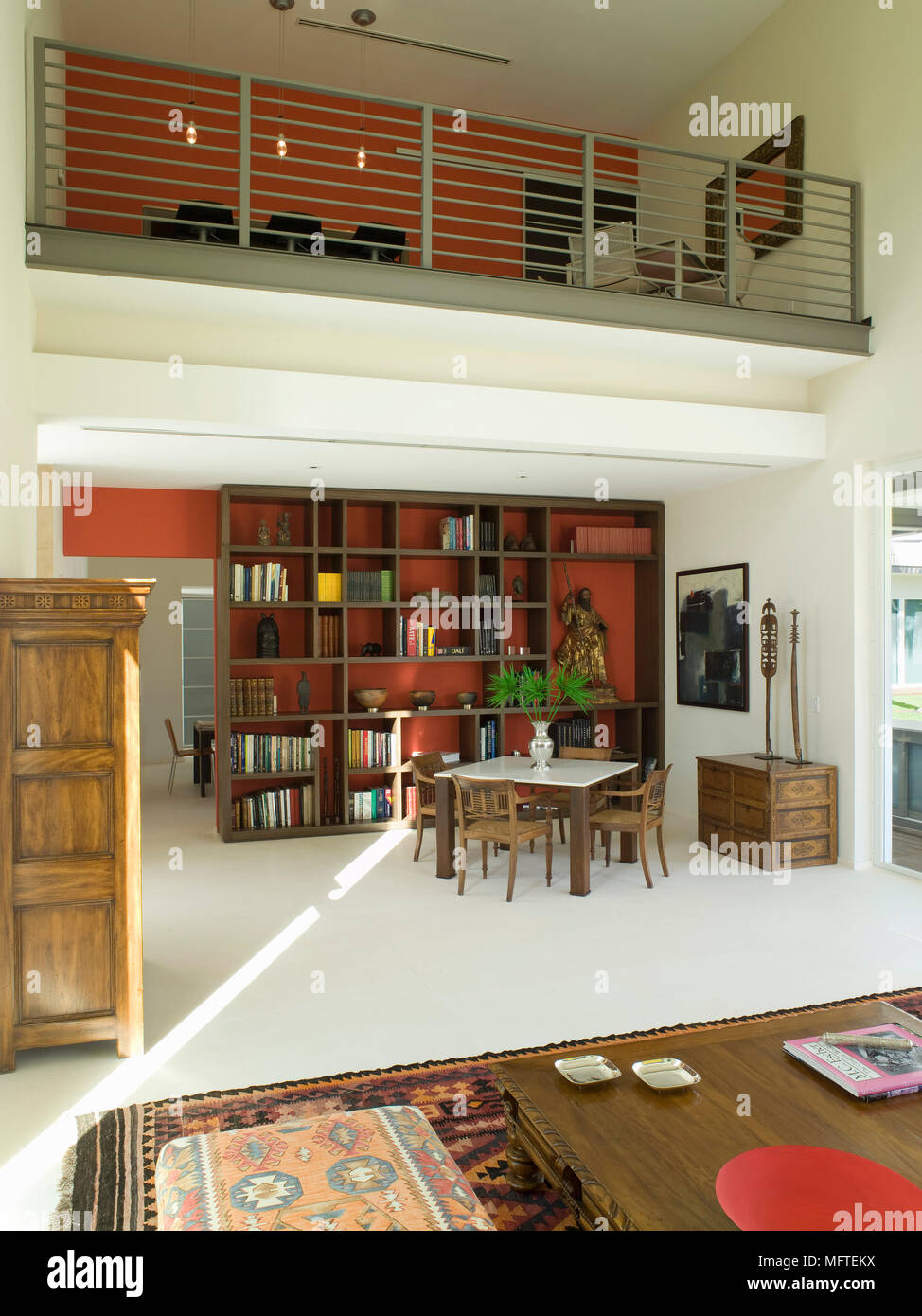 Table and chairs in front of freestanding display unit in spacious open ...