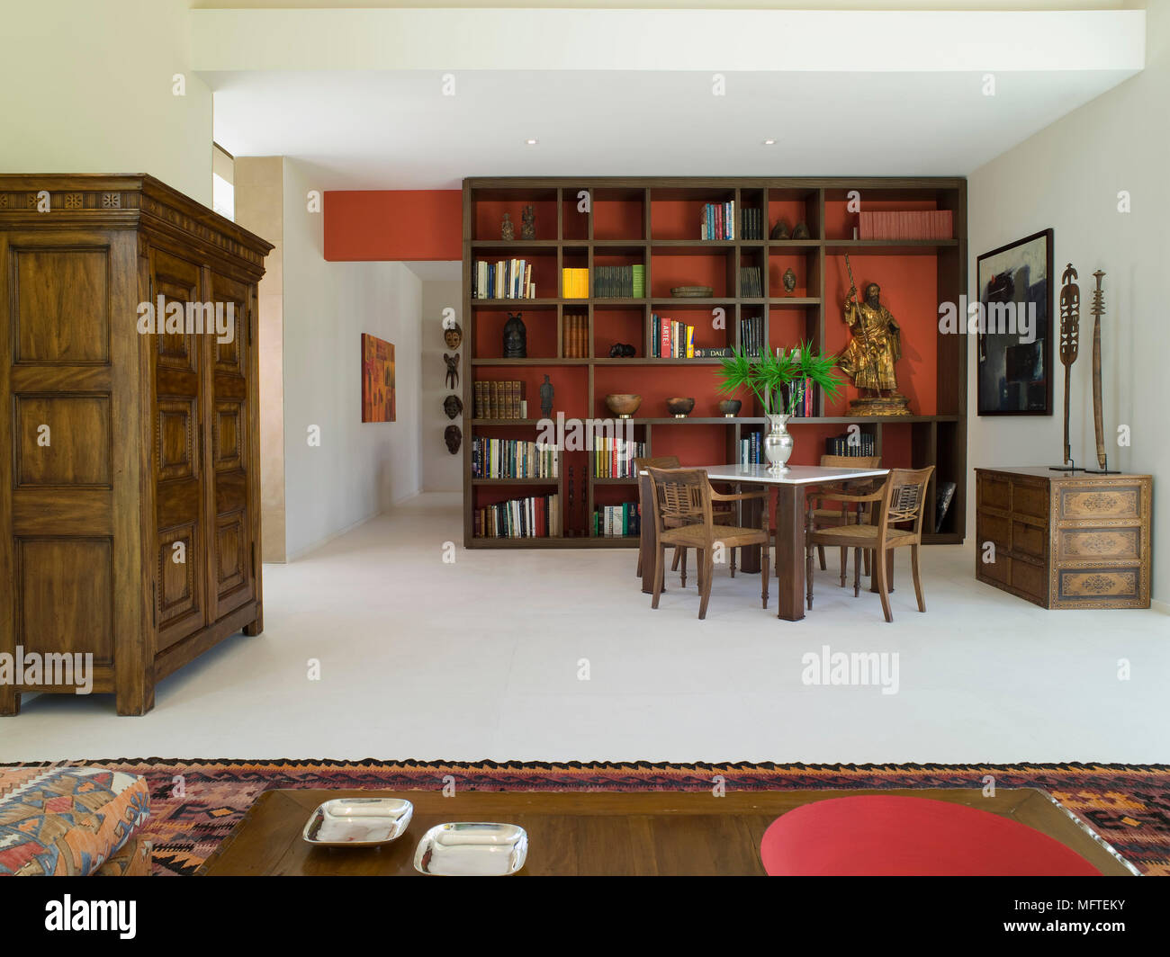 Table and chairs in front of freestanding display unit in spacious open ...