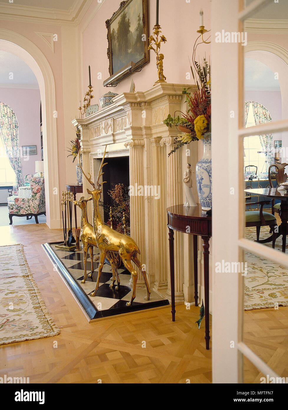 Side view of stone fireplace in opulent room with gold animal statues ...