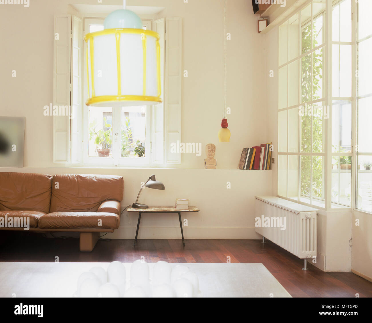 Leather sofa beneath window and lemon ceiling light Stock Photo - Alamy